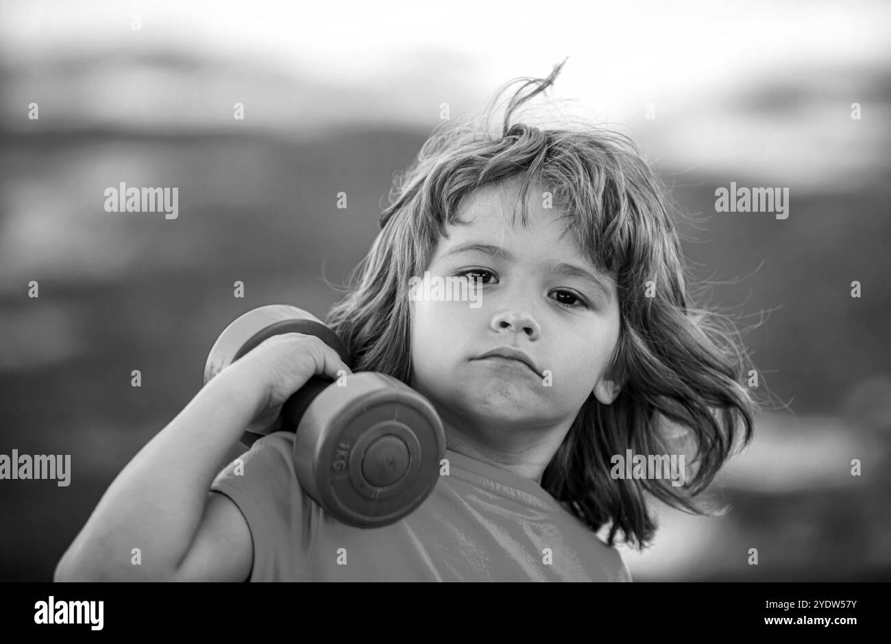 Sporty child boy with dumbbell. Kids sport. Children exercising at park background. Active ...