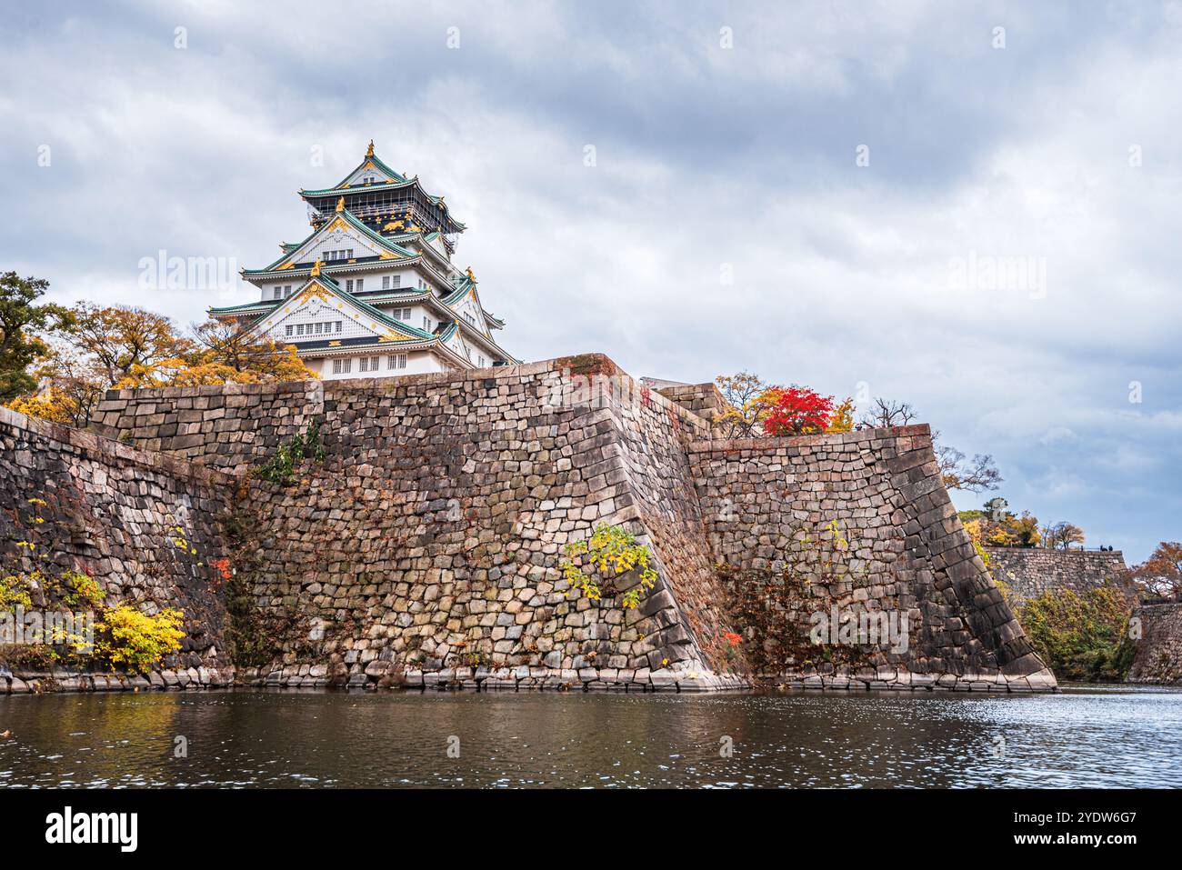 Osaka Castle walls and moat with autumnal foliage, traditional Samurai ...