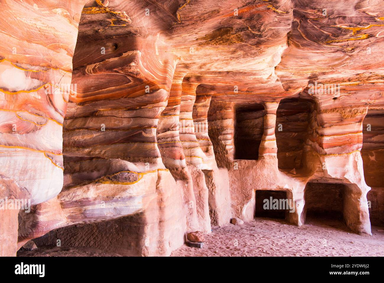 Sandstone caves, multicoloured due to various oxides, containing carved ...