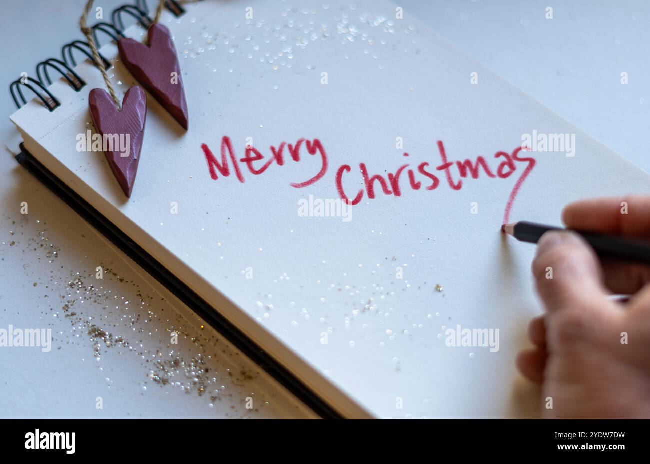 A handwritten Merry Christmas wish on a blank notepad decorated with ...