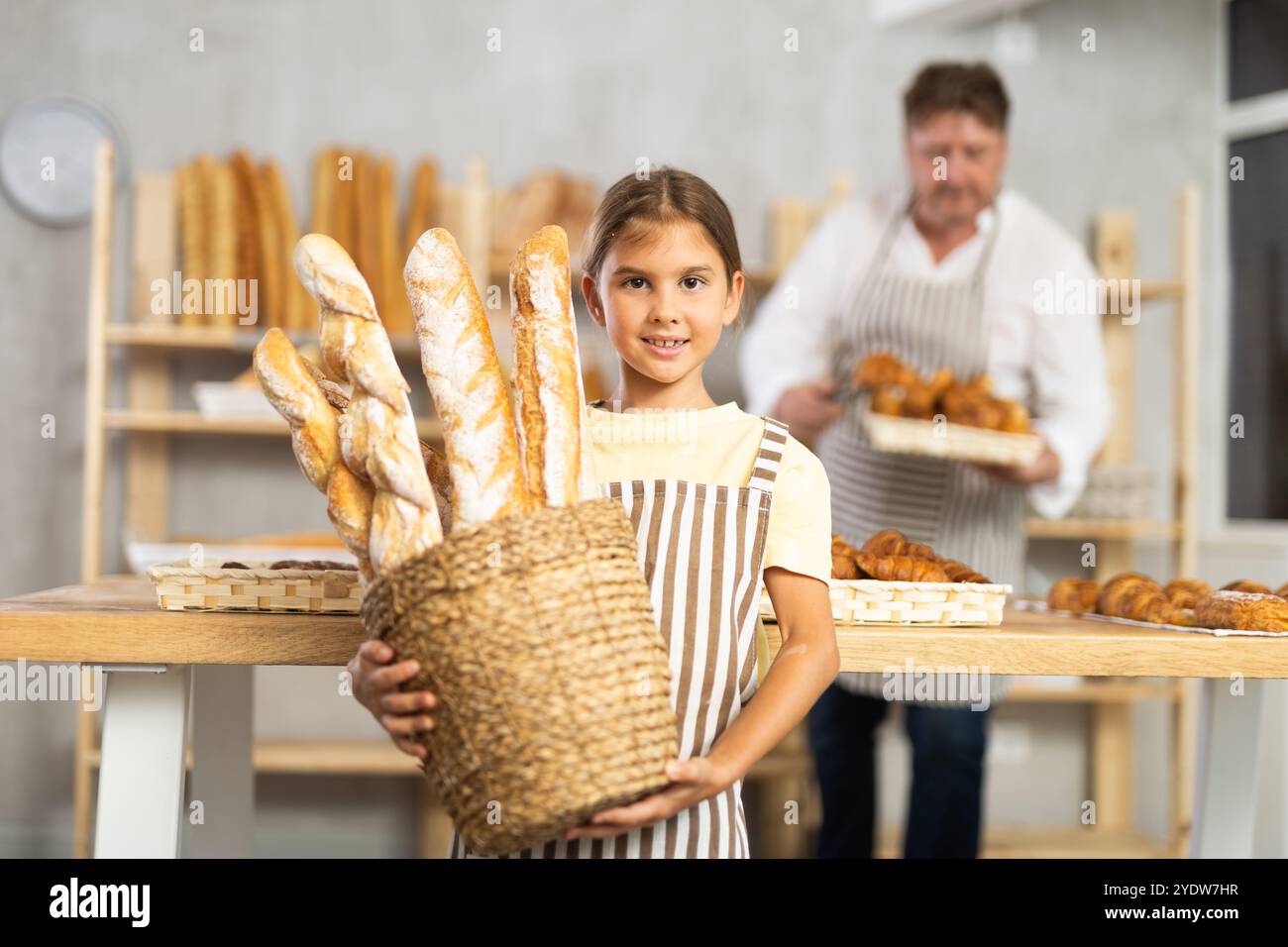 Girl daddy assistant poses in bakery with baguettes of bread Stock ...
