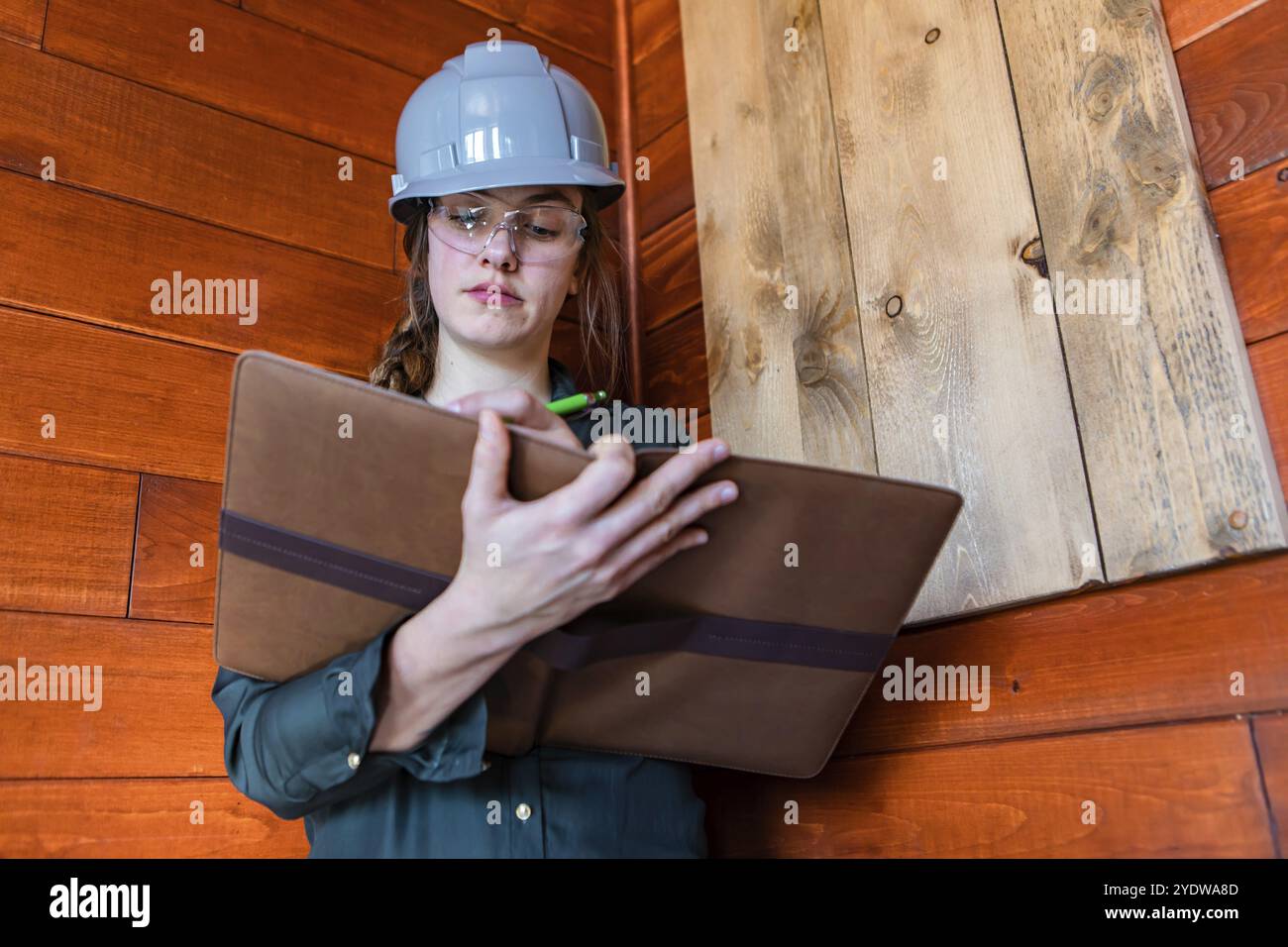 Construction female inspector using a clipboard to taking notes. a ...