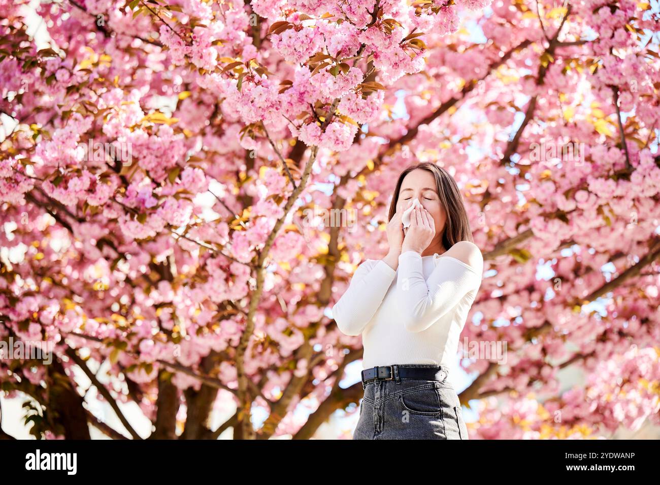 Woman allergic suffering from seasonal allergy at spring in blossoming ...