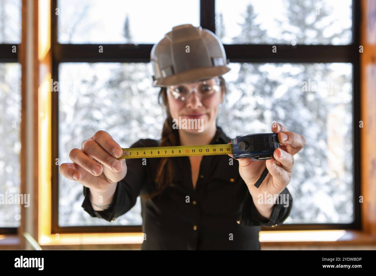 Selective focus on tape measure on woman's hands, she is a construction ...