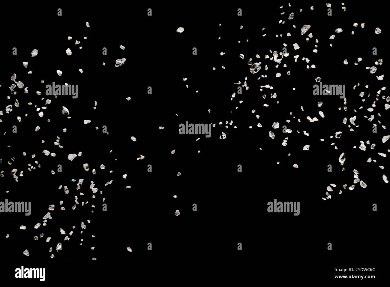 Studio shot of black stone textured splatter in black background. Split ...