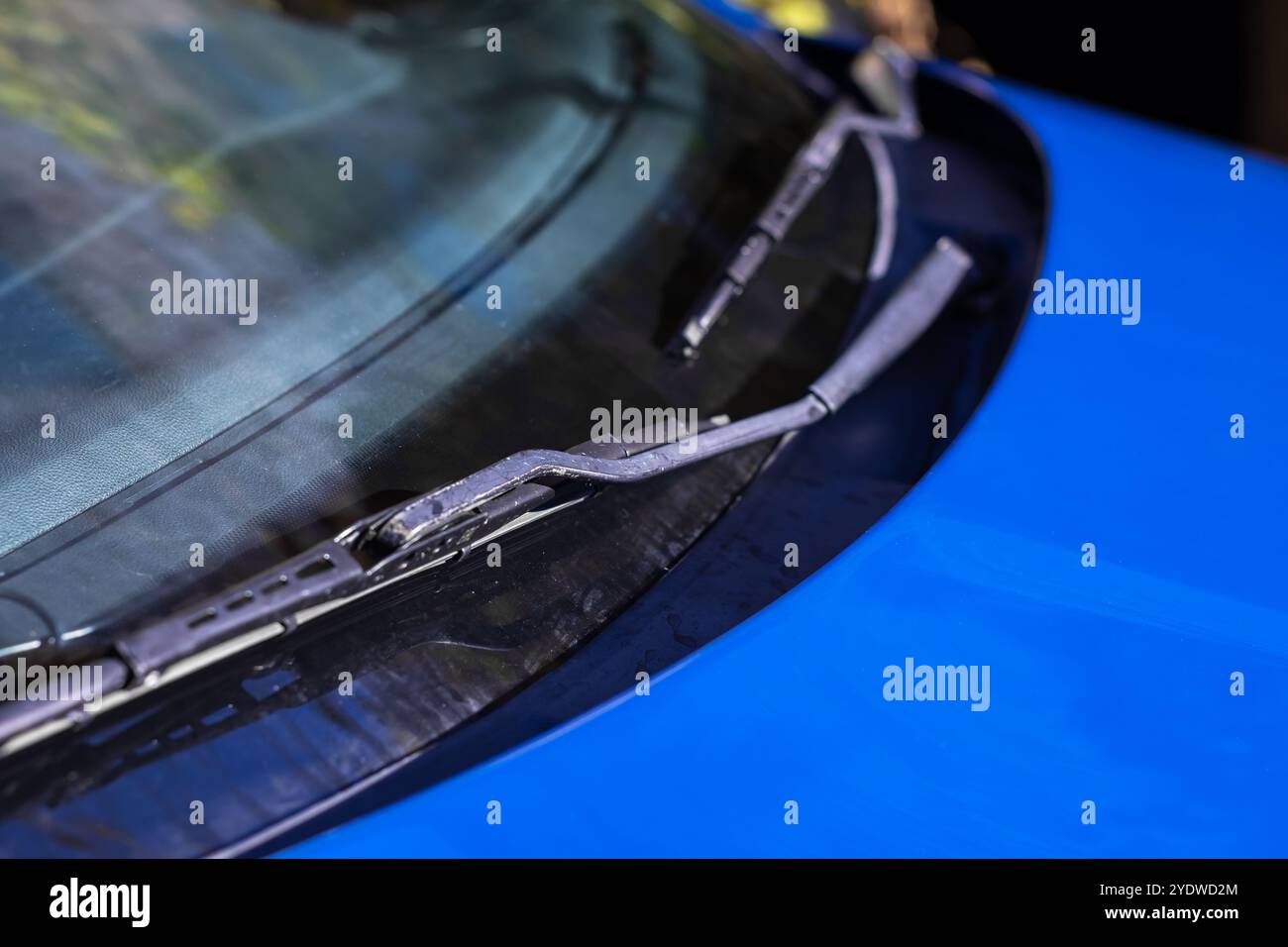 This image features an upclose view of a windshield wiper carefully ...