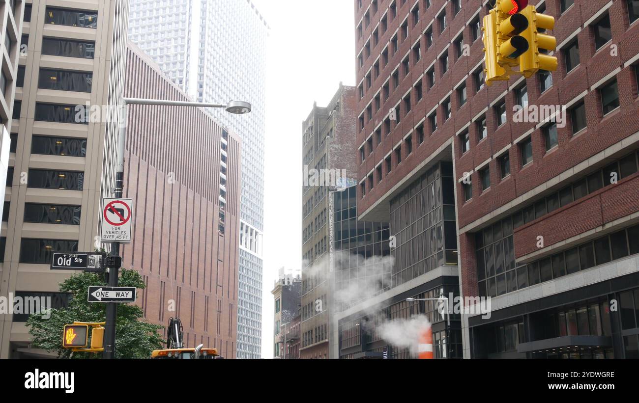 Steam vapor vented on New York City Water street, orange vapour tube ...