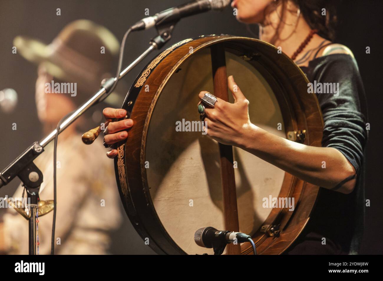 A closeup view of a female musician using a large drum and microphone ...