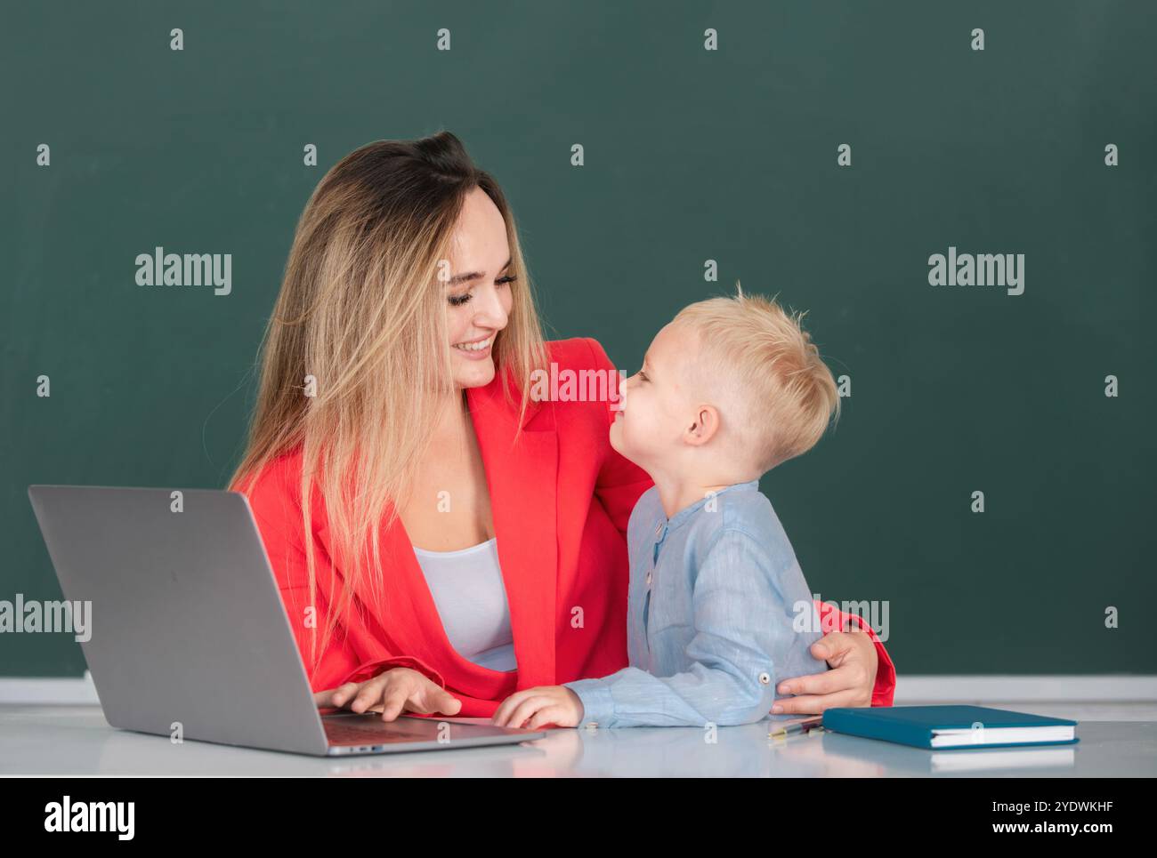 Portrait of schoolkids and teacher talking at school lesson. Mother and ...