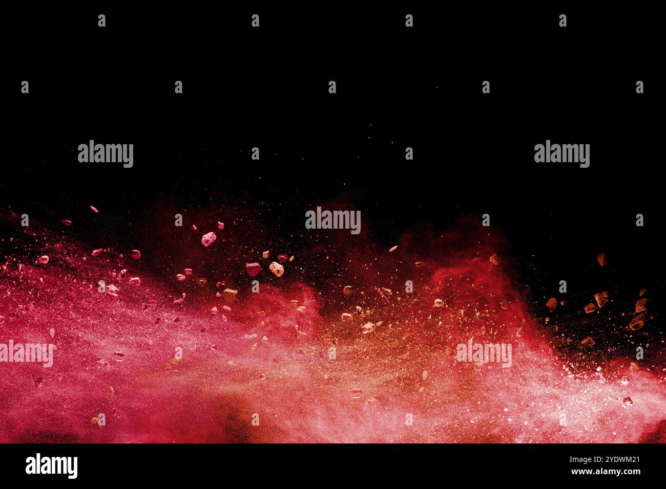 Split debris of stone exploding with orange powder splash against black ...