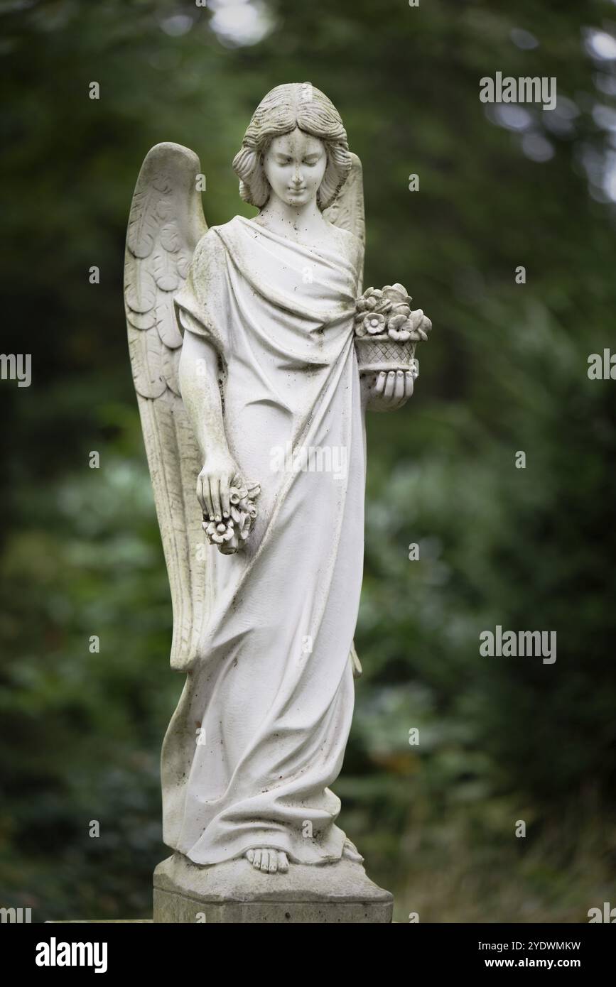 A white angel figure in a cemetery against a blurred background Stock ...
