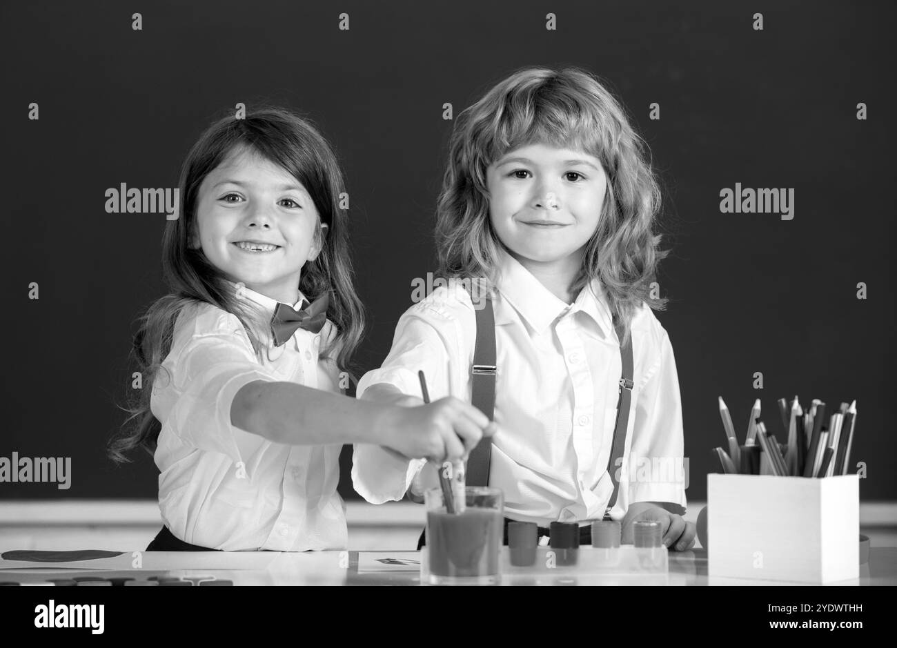 School children drawing a colorful pictures with pencil crayons in ...