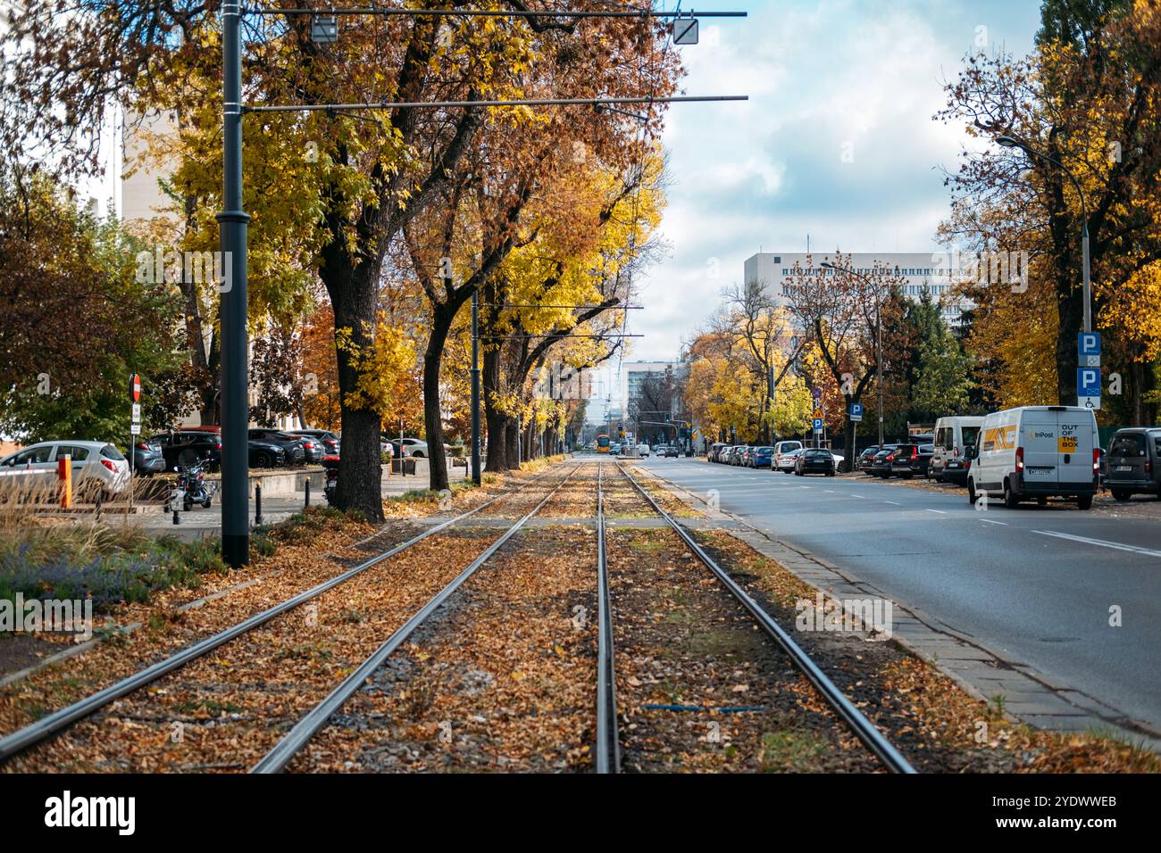 Autumn street scene in Warsaw with tram tracks, colorful trees, and ...