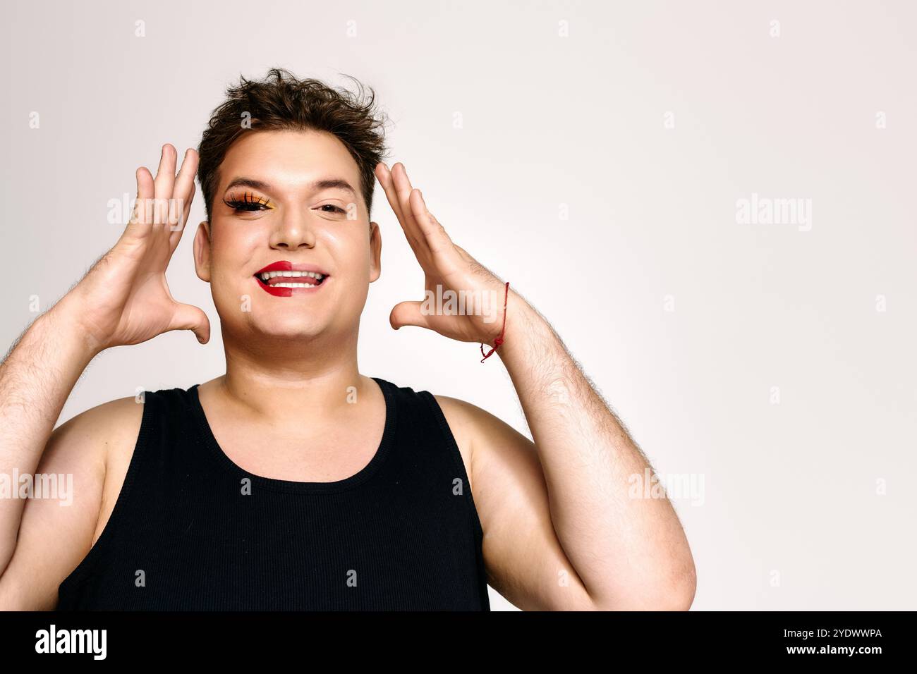 A joyful individual showcases bold makeup while expressing unique ...