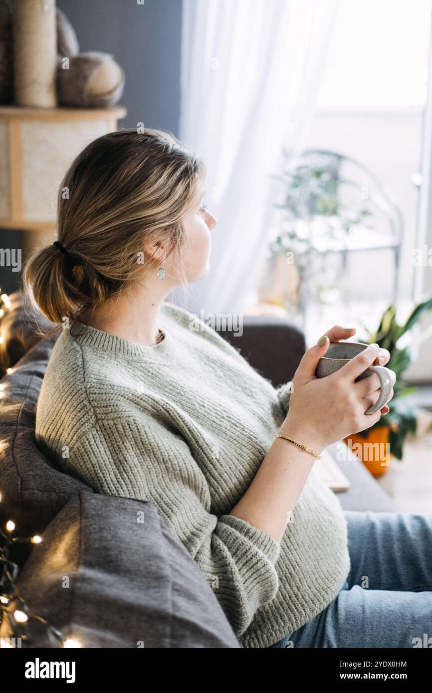 Pregnant woman practicing relaxation with a warm cup of tea, embracing ...