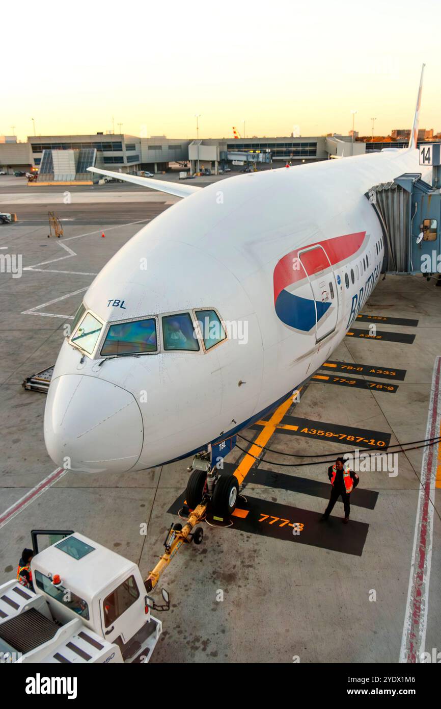 A British Airways Boeing 777 is parked at the gate with airport ground ...