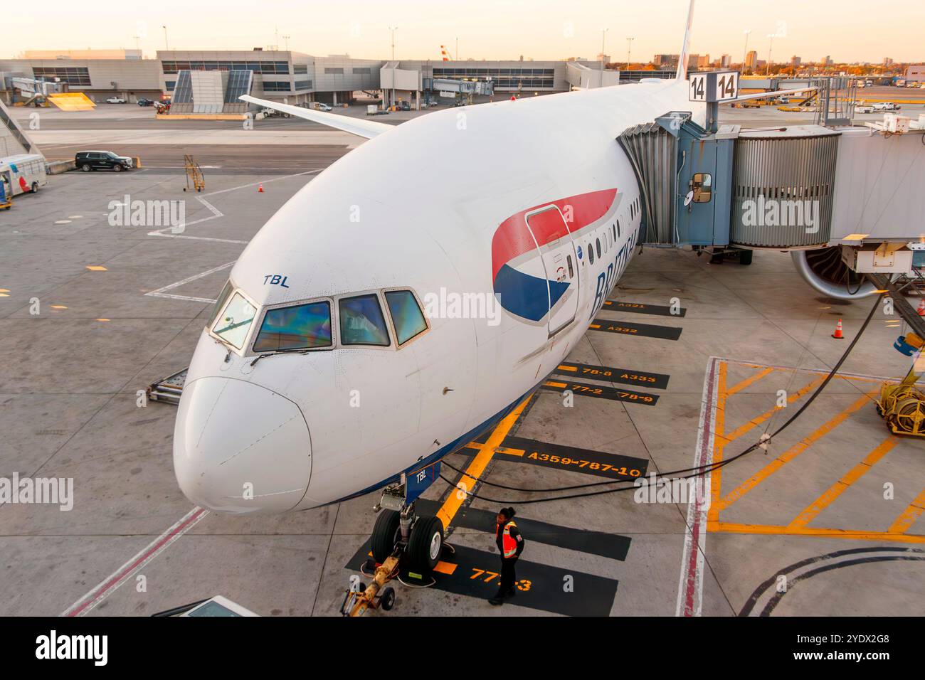 A British Airways Boeing 777 is parked at the gate with airport ground ...