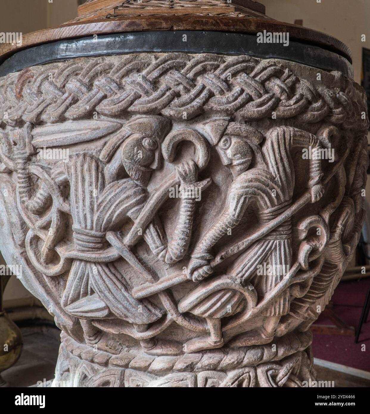 12th century Norman Font depicting two battling men dressed in the same ...