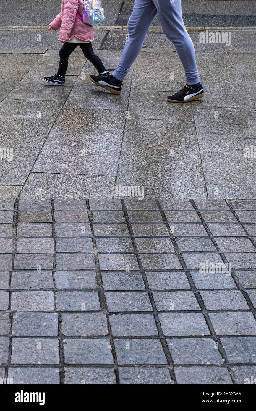 People walking along the pavement sidewalk in Newquay town centre in ...