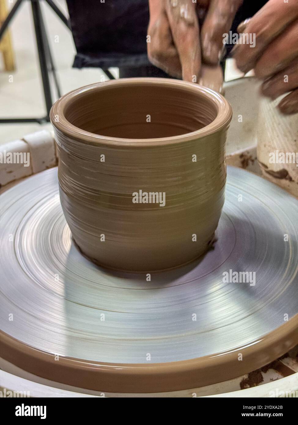 Handcrafting ceramics on a pottery wheel. Male hands shaping a clay ...