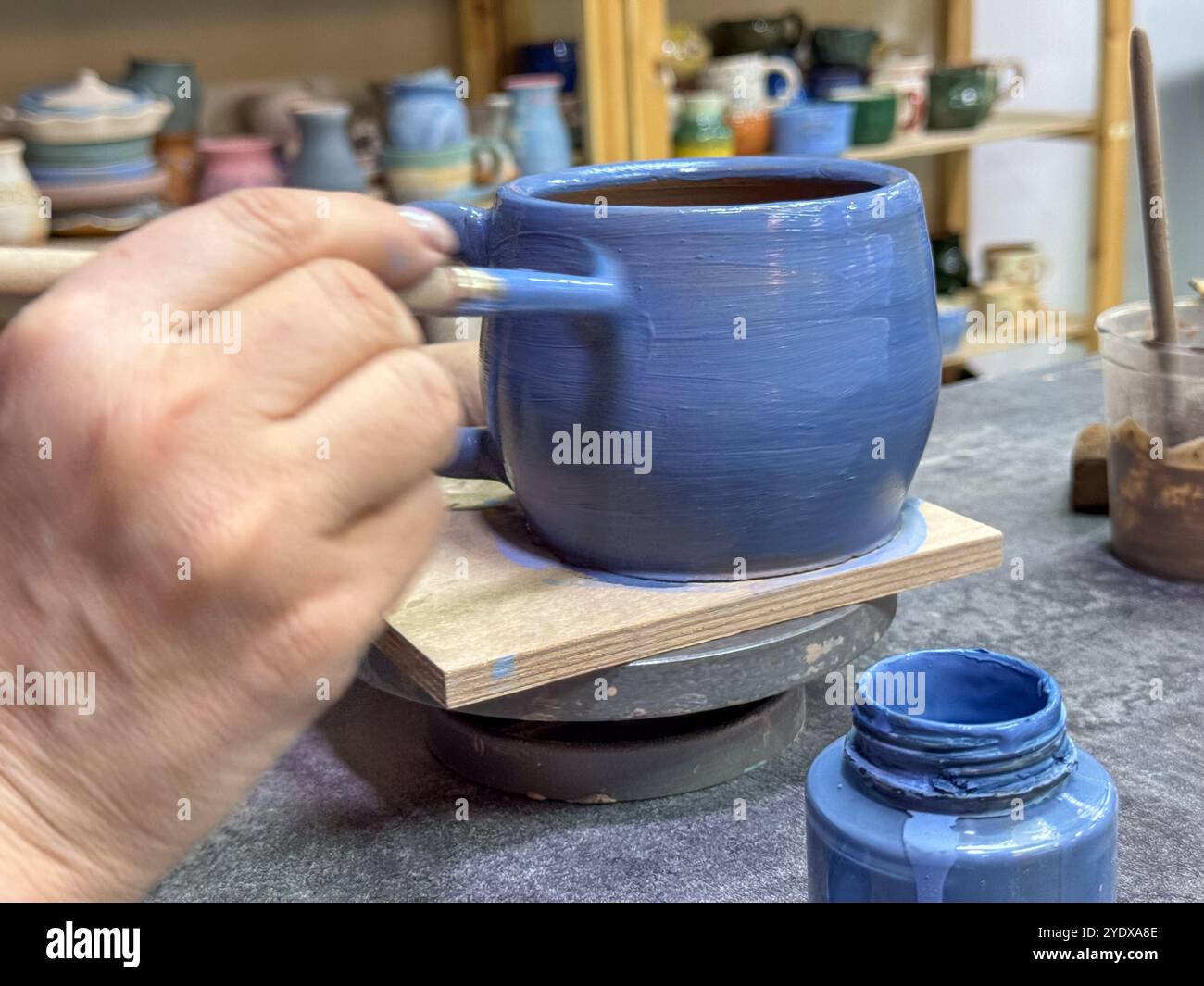 The process of painting a clay vase during a ceramics masterclass ...
