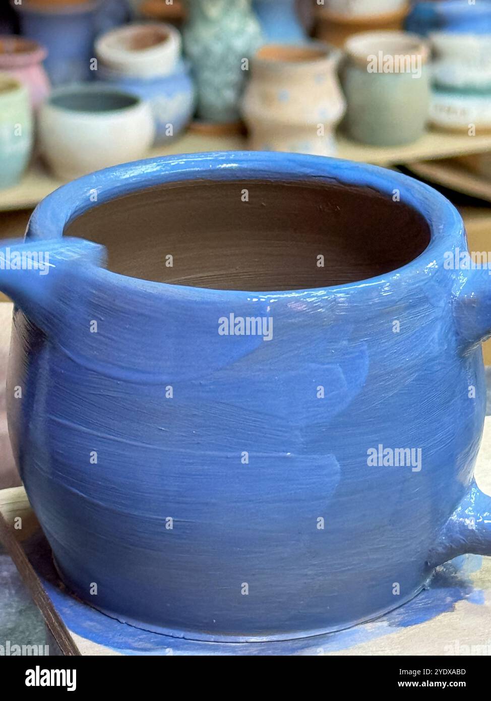 The process of painting a clay vase during a ceramics masterclass ...