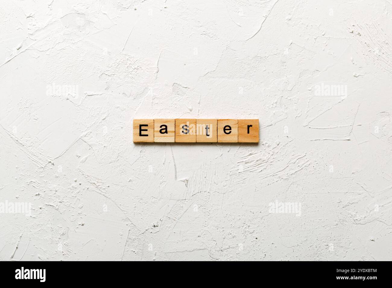 Easter word written on wood block. Easter text on cement table for your ...