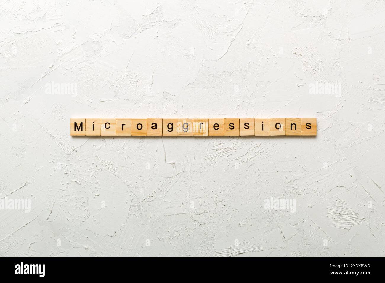 Microaggressions word written on wood block. Microaggressions text on ...