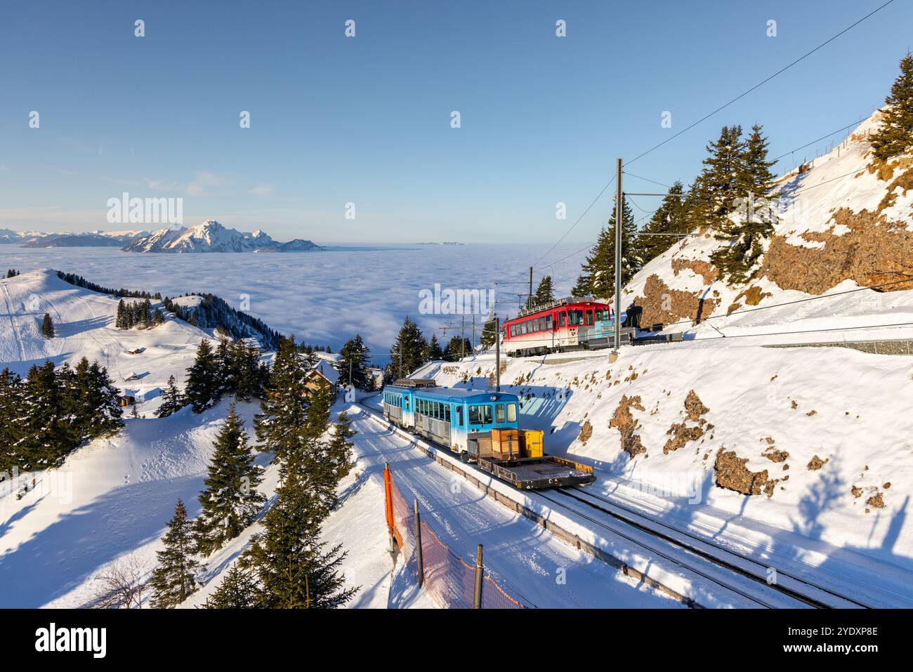 blue and red rigibahn trains are climbing the summit of mount rigi ...
