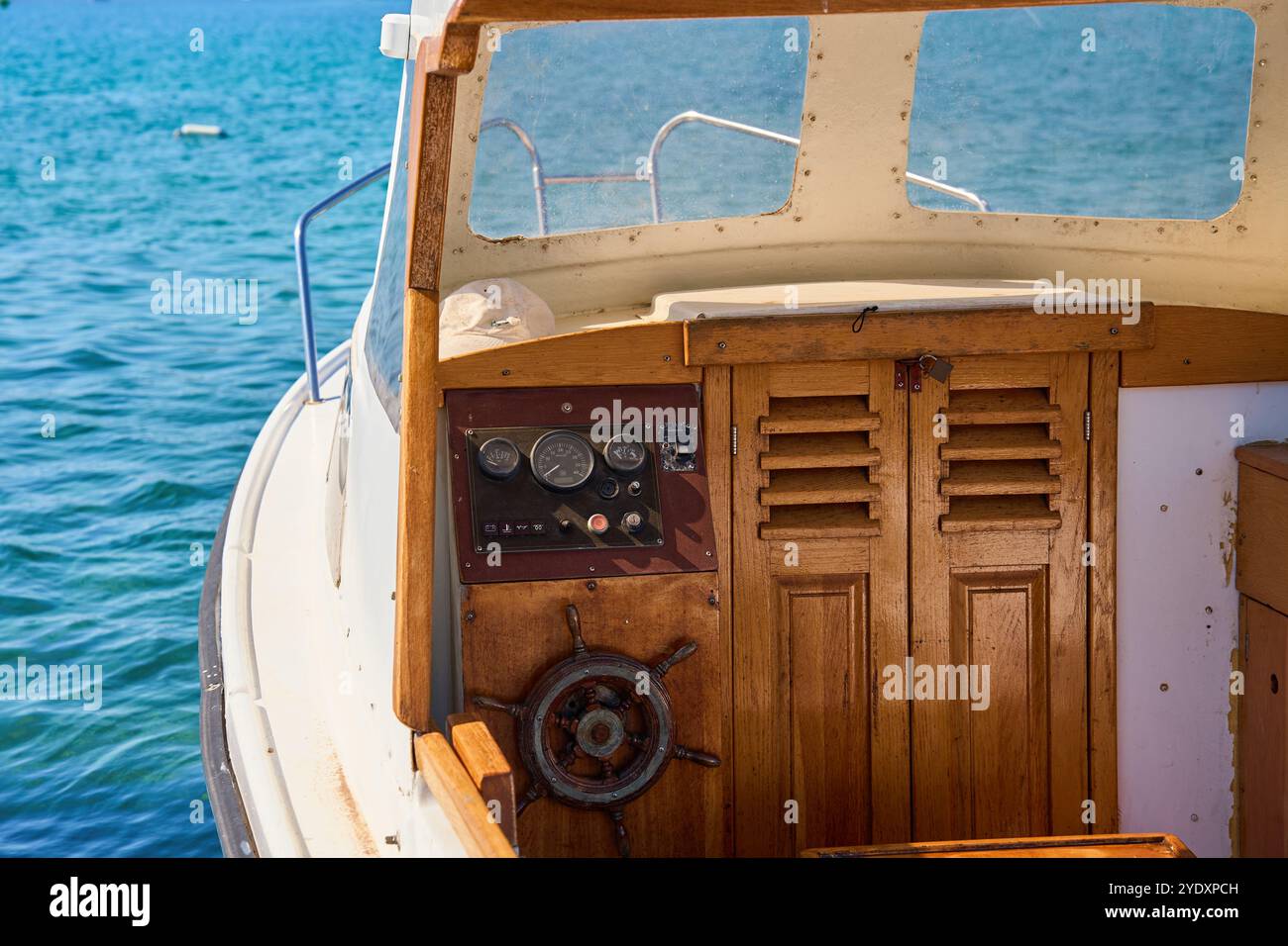Wooden cockpit of small boat with steering wheel, gauges and cabin ...