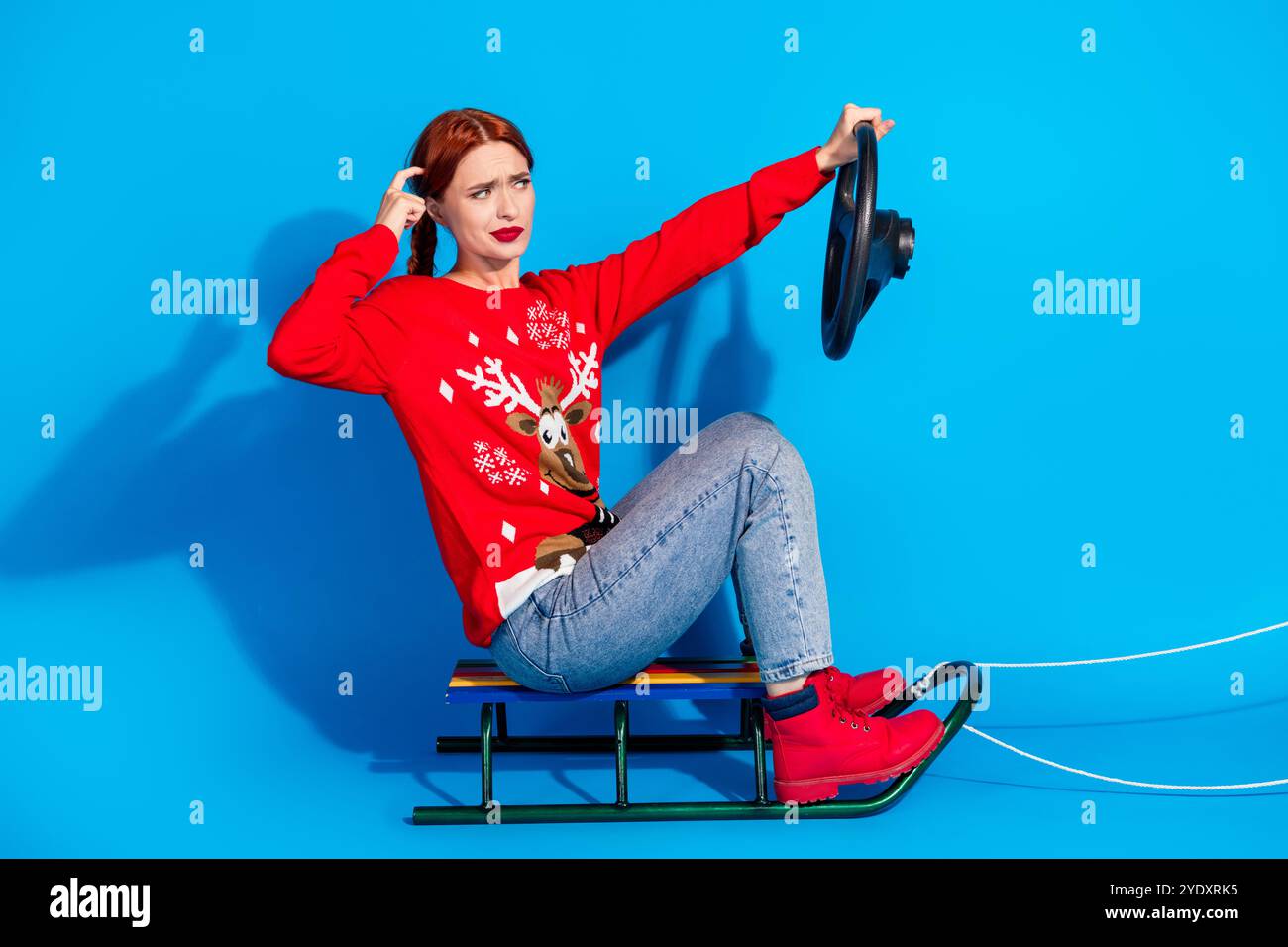Full body photo of young woman ride sledge confused hold steering wheel ...