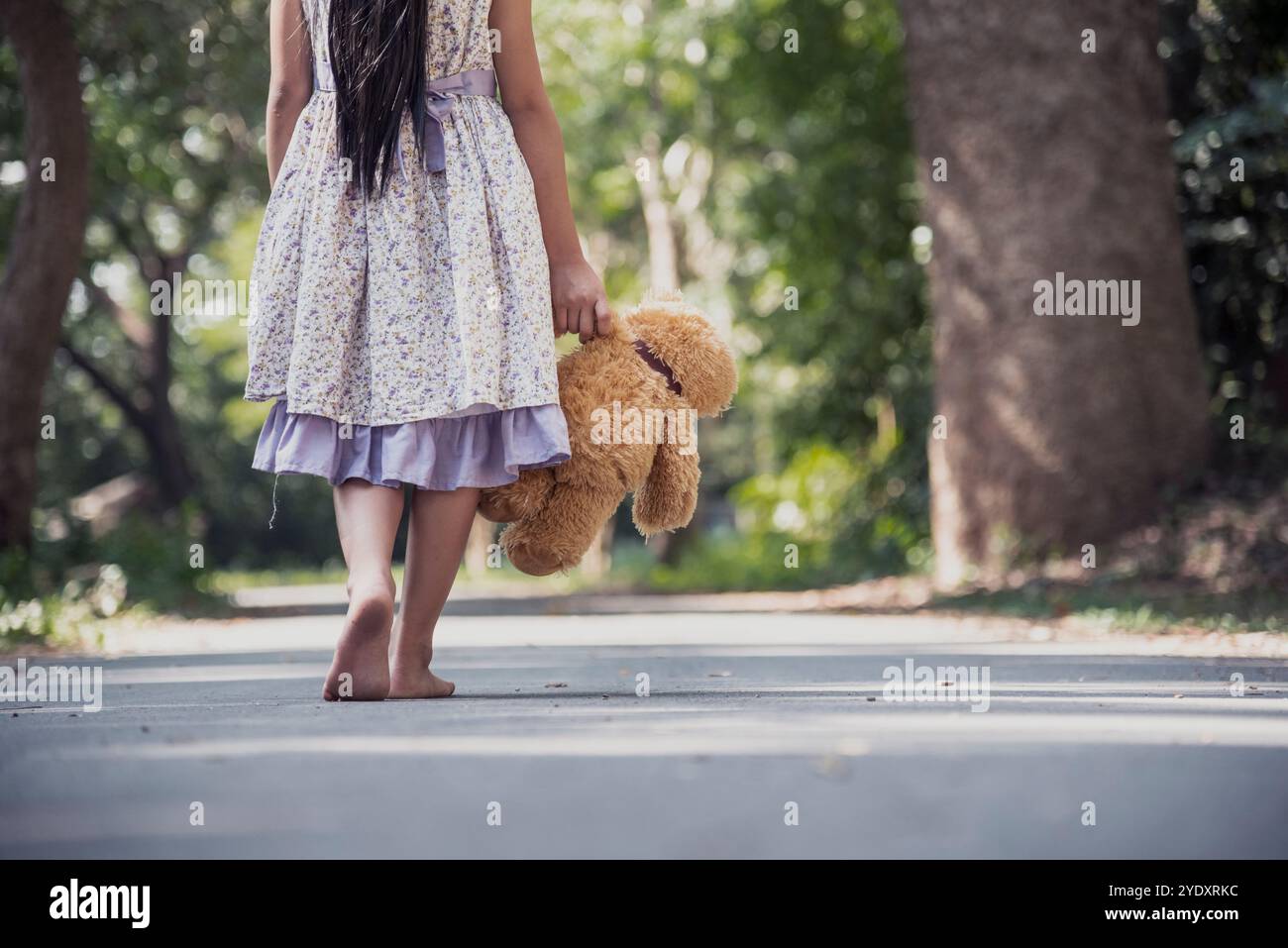 Sad girl hugging teddy bear sadness alone in green garden park. Lonely ...
