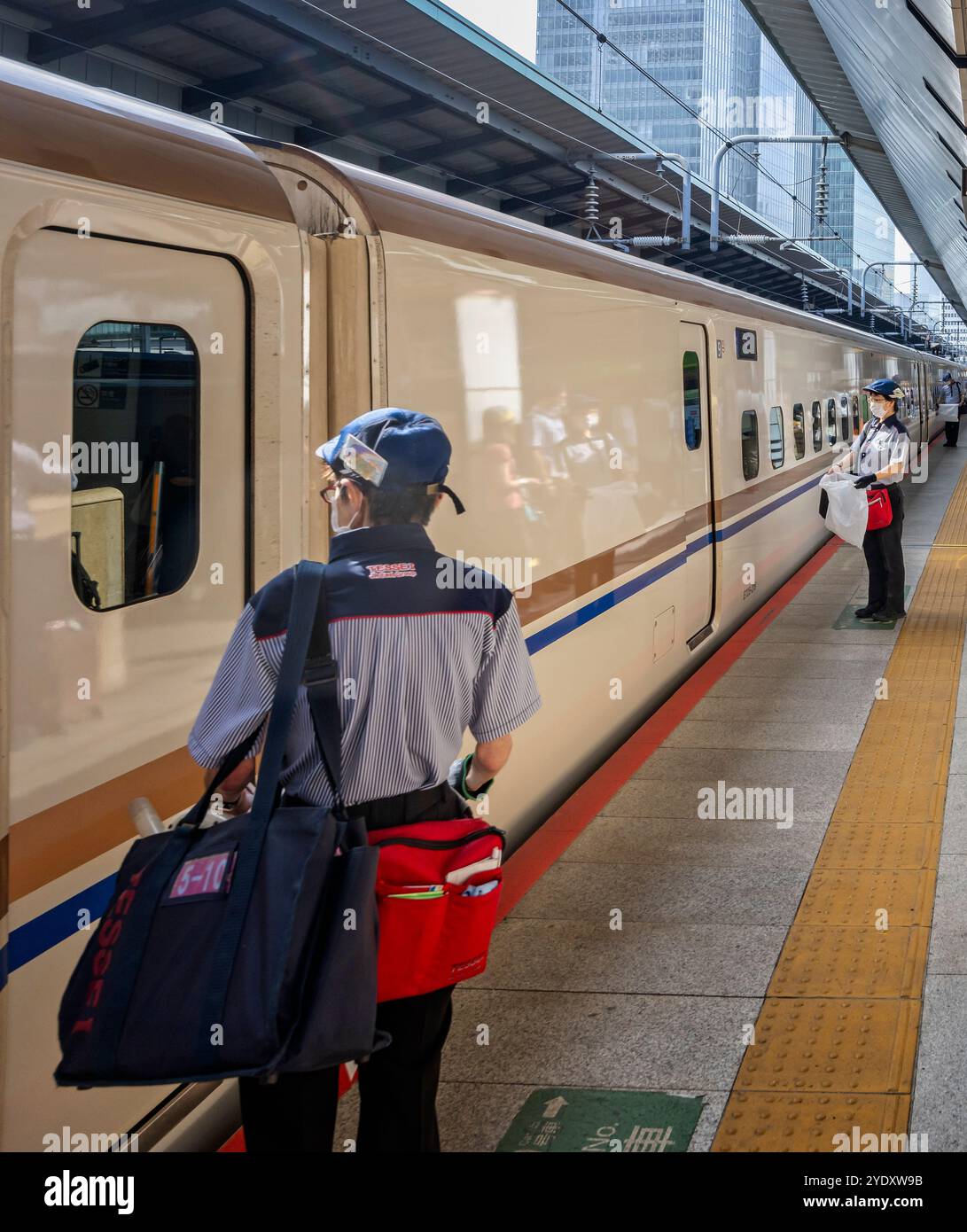 Cleaners waiting to board and clean Japanese bullet train at the ...