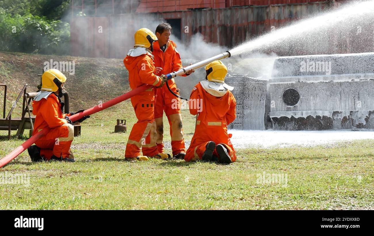 Firefighter fighting with flame using fire hose chemical water foam ...