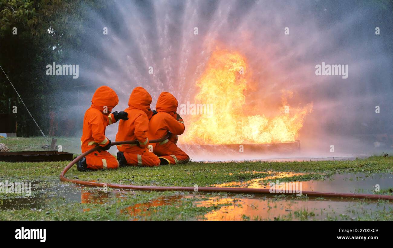 Firefighter fighting with flame using fire hose chemical water foam ...