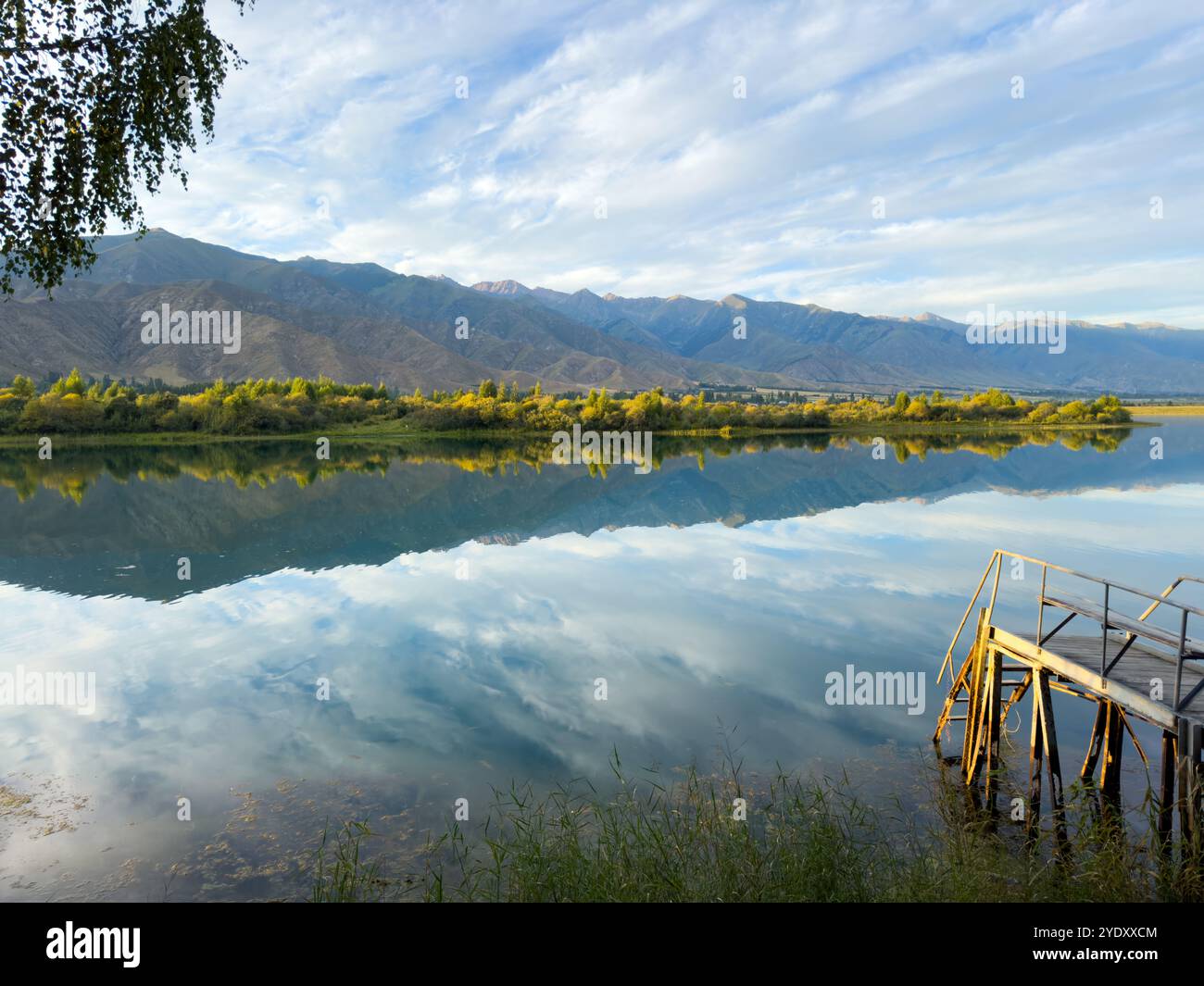 The calm water surface of Issyk-Kul lake with majestic mountains in the ...
