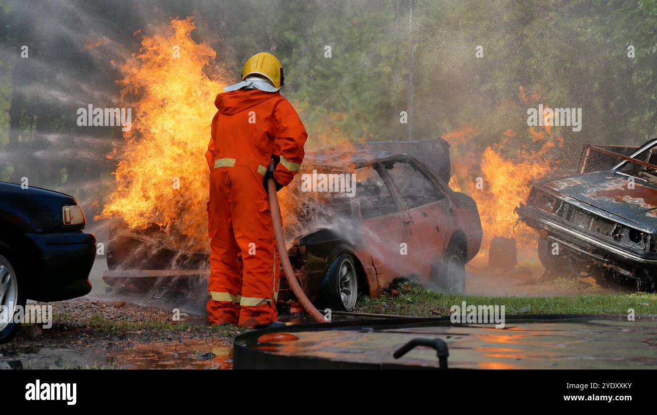 Firefighter fighting with flame using fire hose chemical water foam ...