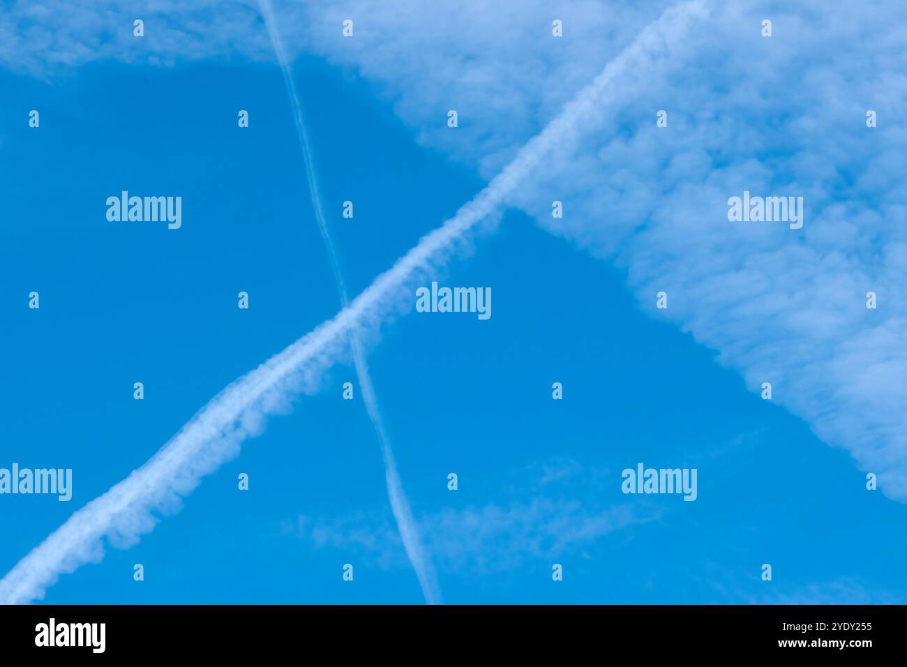 Vapour trails in blue sky from aircraft travel crossing and spreading ...
