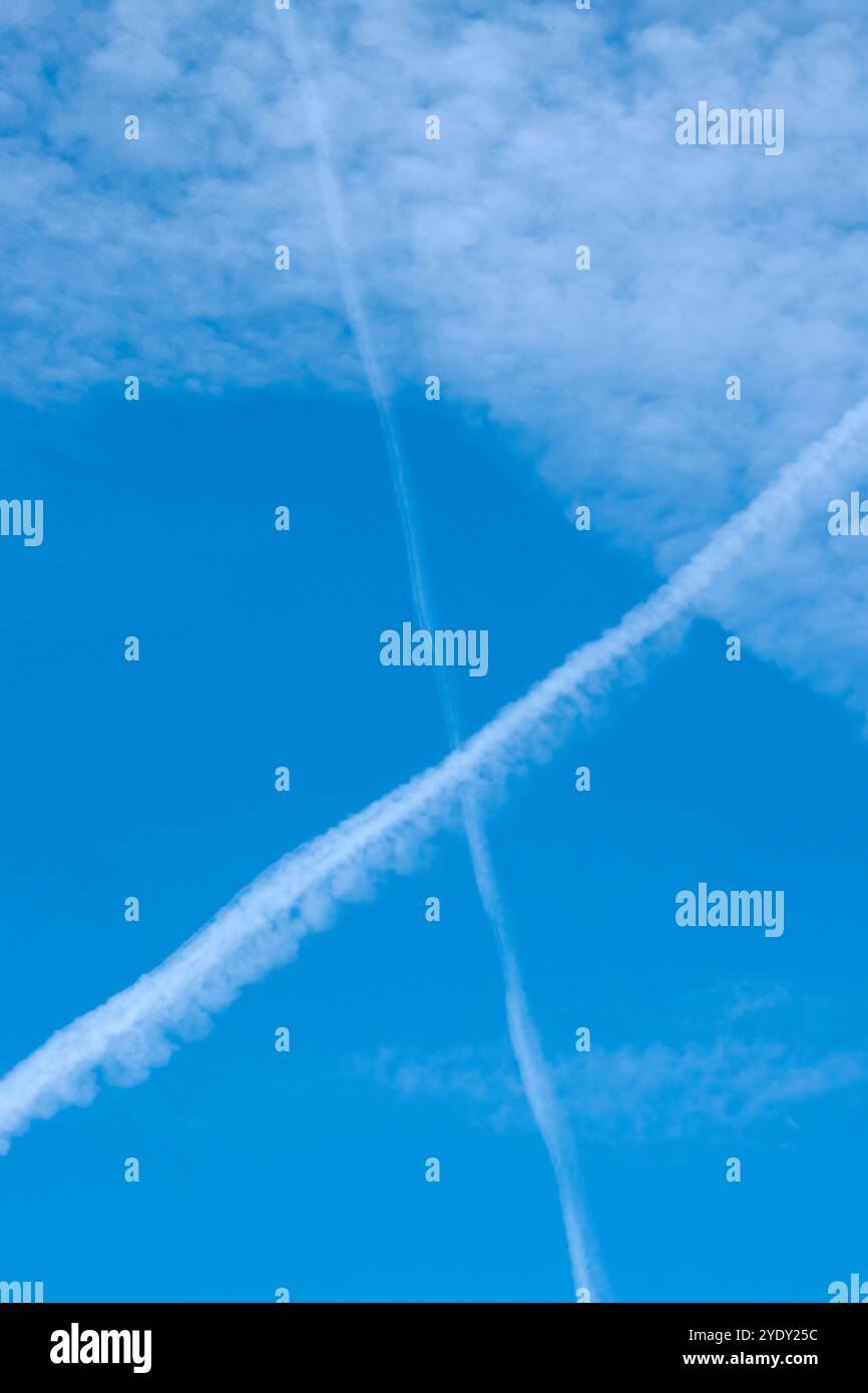 Vapour trails in blue sky from aircraft travel crossing and spreading ...
