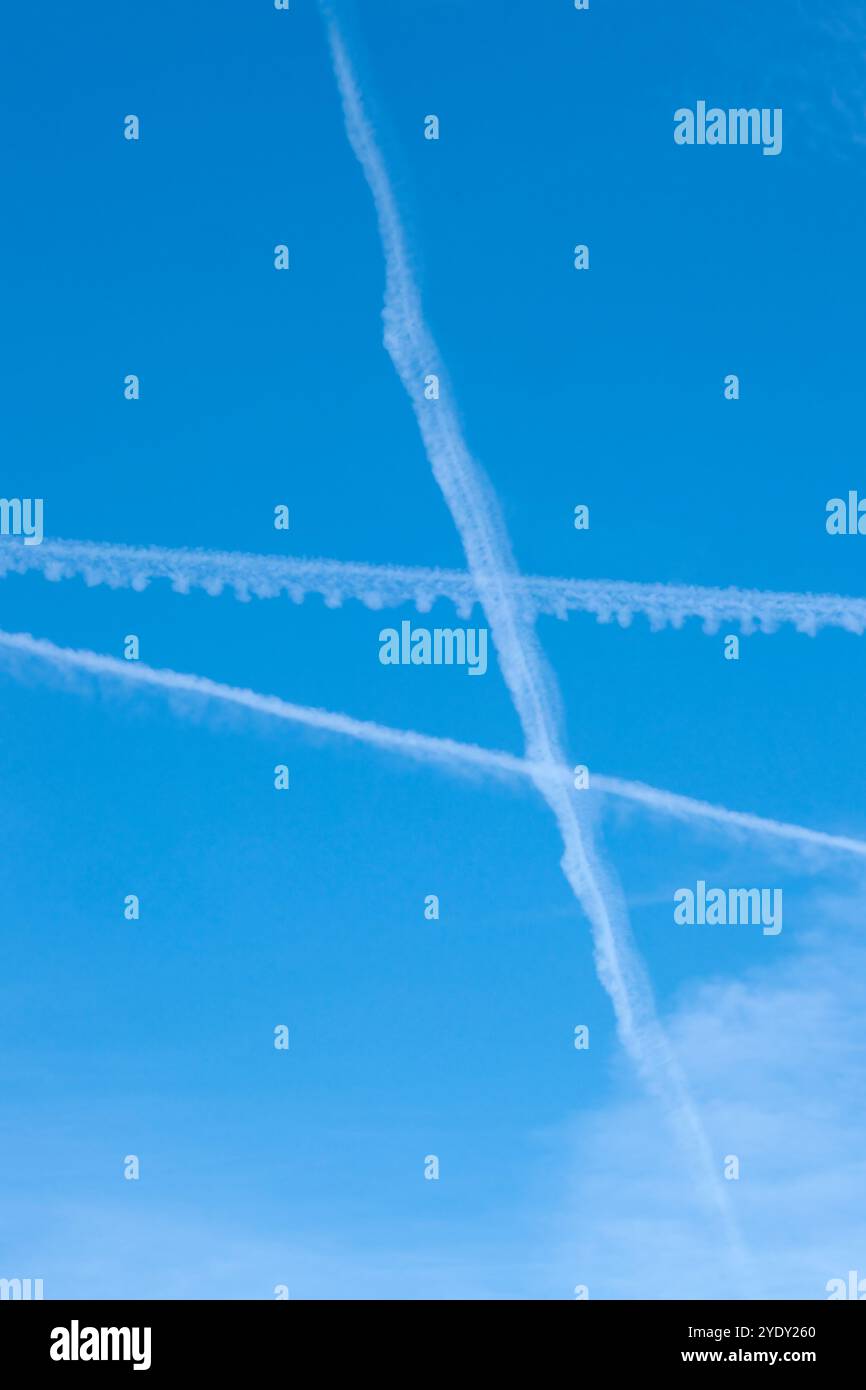 Vapour trails in blue sky from aircraft travel crossing and spreading ...
