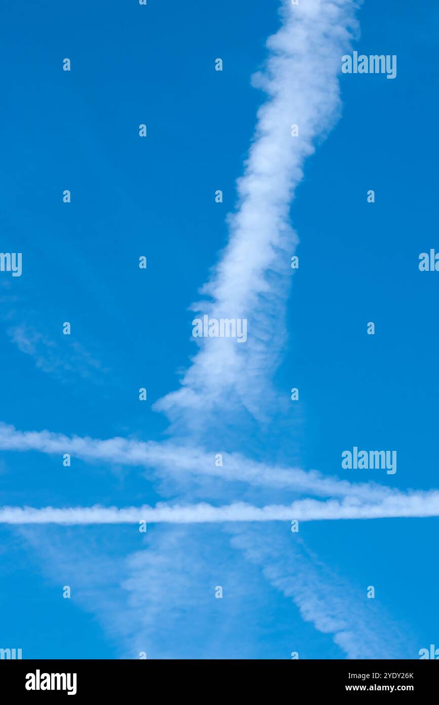 Vapour trails in blue sky from aircraft travel crossing and spreading ...