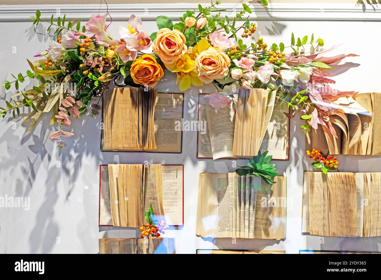 decorative wall decoration with books and fresh flowers. Interior items ...