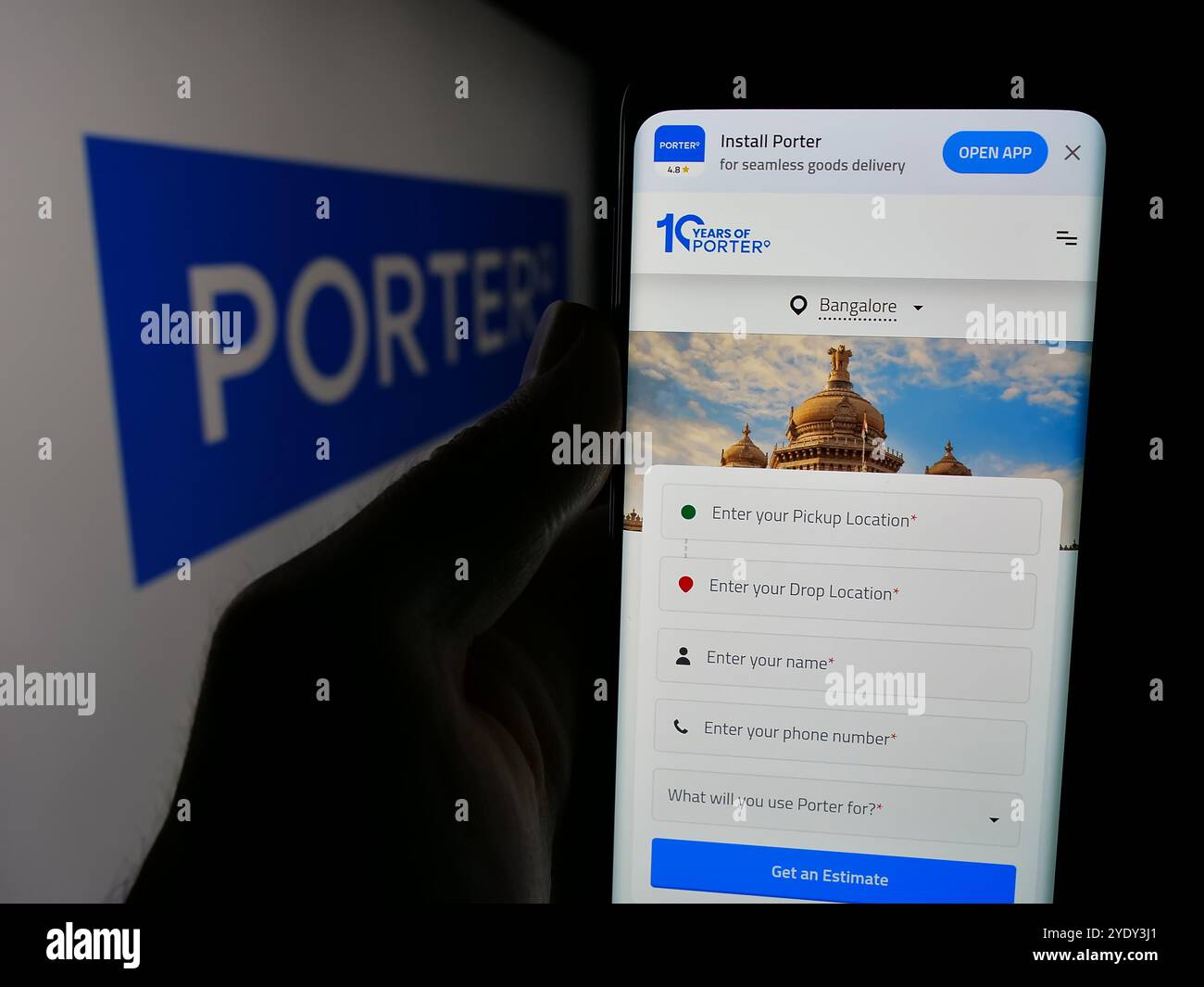 Person holding cellphone with webpage of Indian logistics company ...