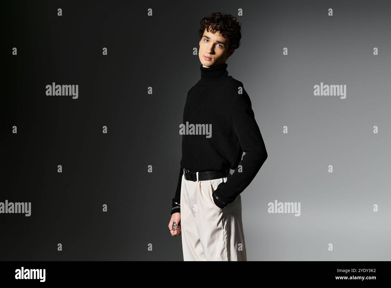 A dapper young man poses confidently, showcasing his curly hair and ...