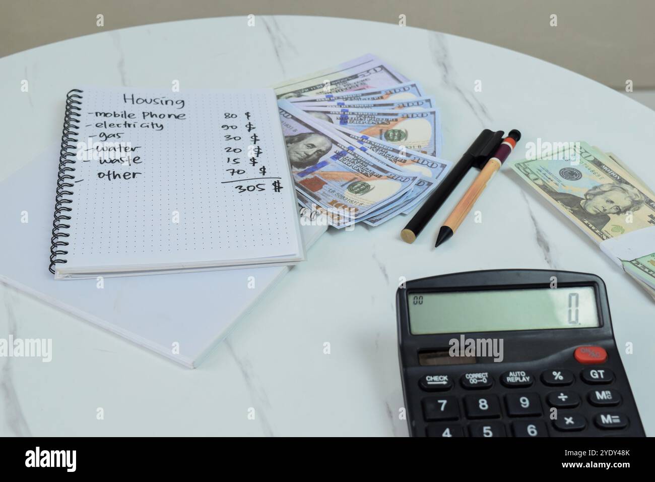 Dollar cash money with notebook handwritten housing expenses, counting ...
