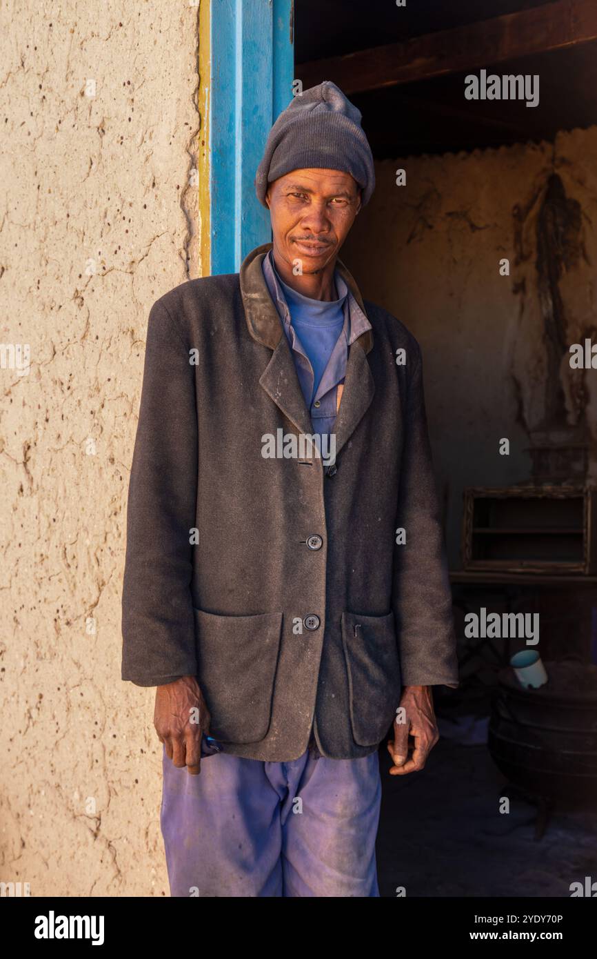 village mature african man standing in the door frame in front of his ...