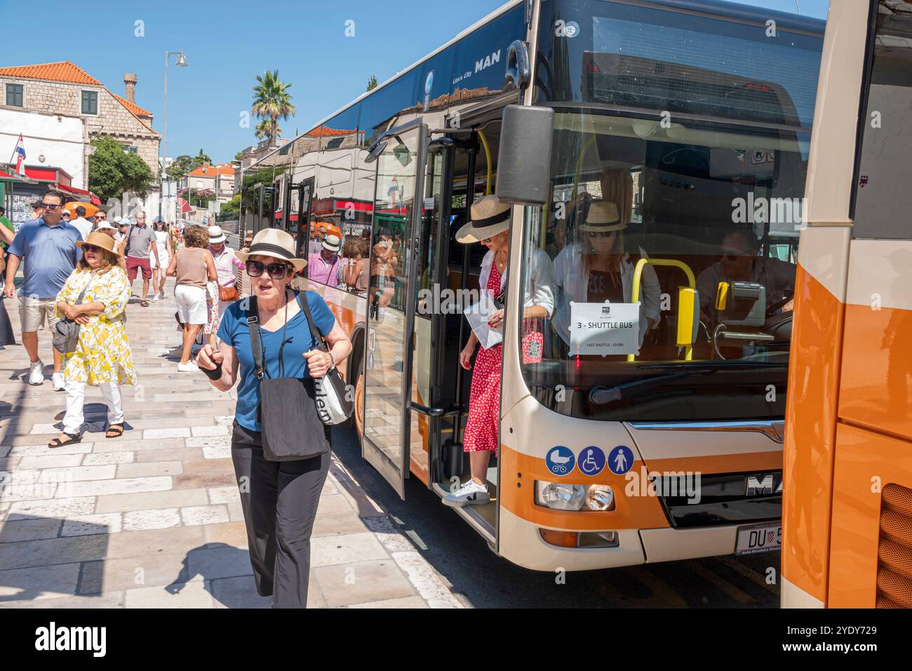 Passengers getting off shuttle bus guide agent hi-res stock photography ...