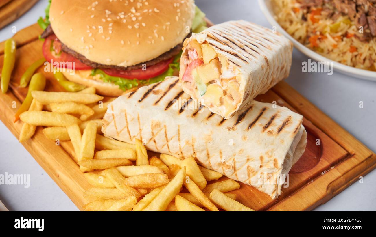 Tasty doner kebab with fries and burger on white background Stock Photo ...