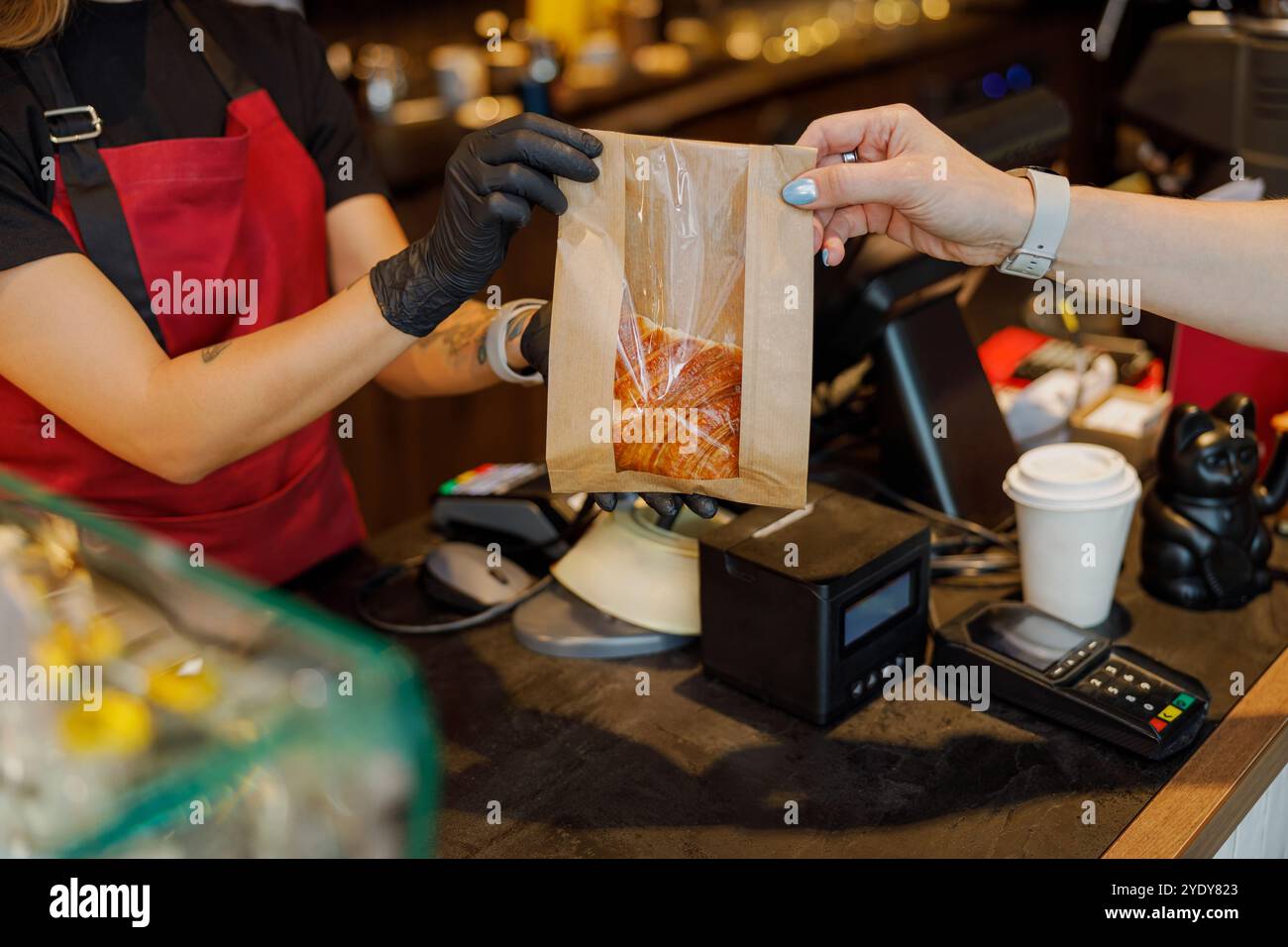 A customer is receiving their order at the coffee shop counter ...