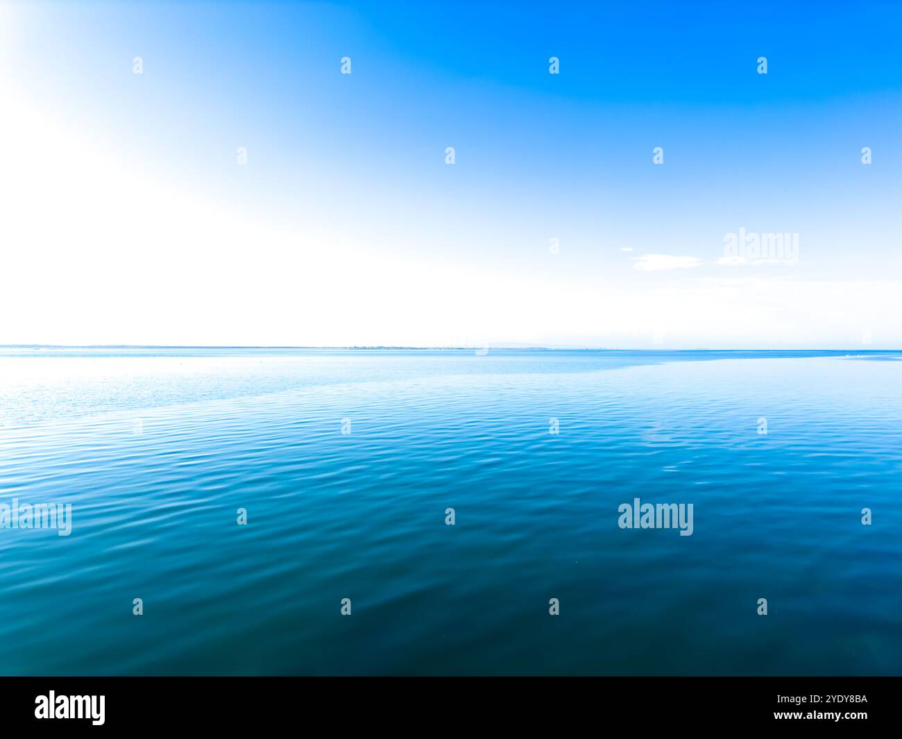A horizontal line of water and sky with a smooth transition of colors ...